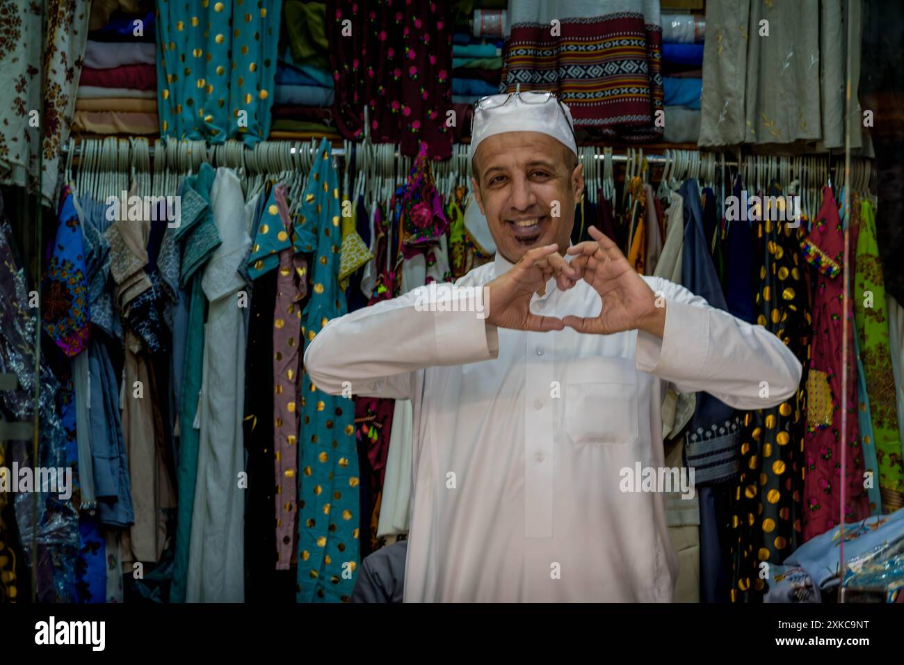 The local shop owner showing heart with his hands at the street of ...