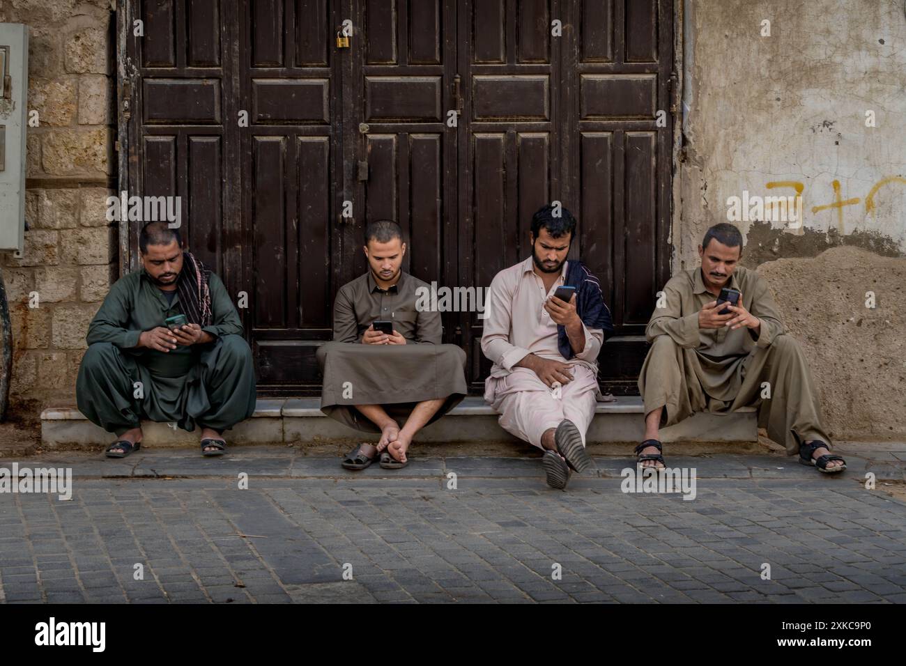 The local Arab men sitting on the porch of the old Saudi building in ...