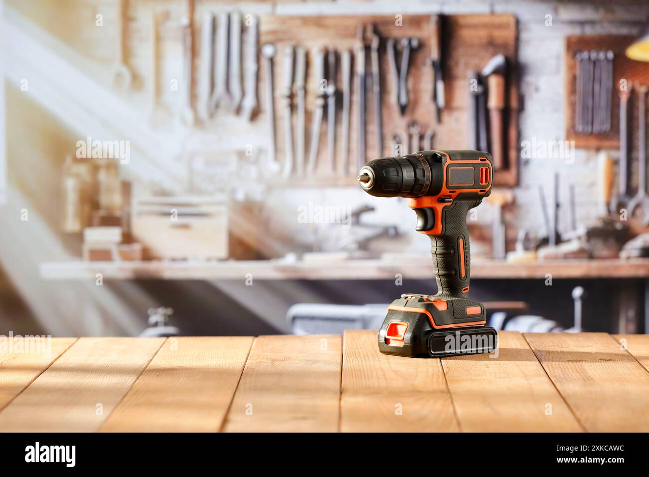 Electric cordless drill screwdriver tool on wooden work table in craft ...