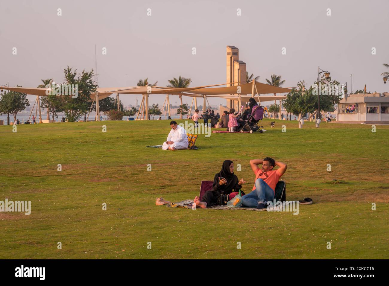 Arab people having fun on the grass in the park of Jeddah watefront (Al ...