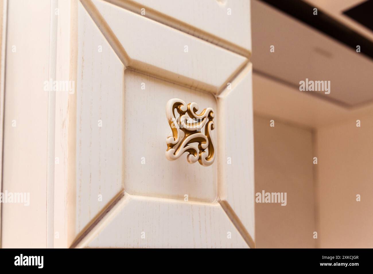 Detailed close-up of an ornate cabinet handle on a white kitchen ...