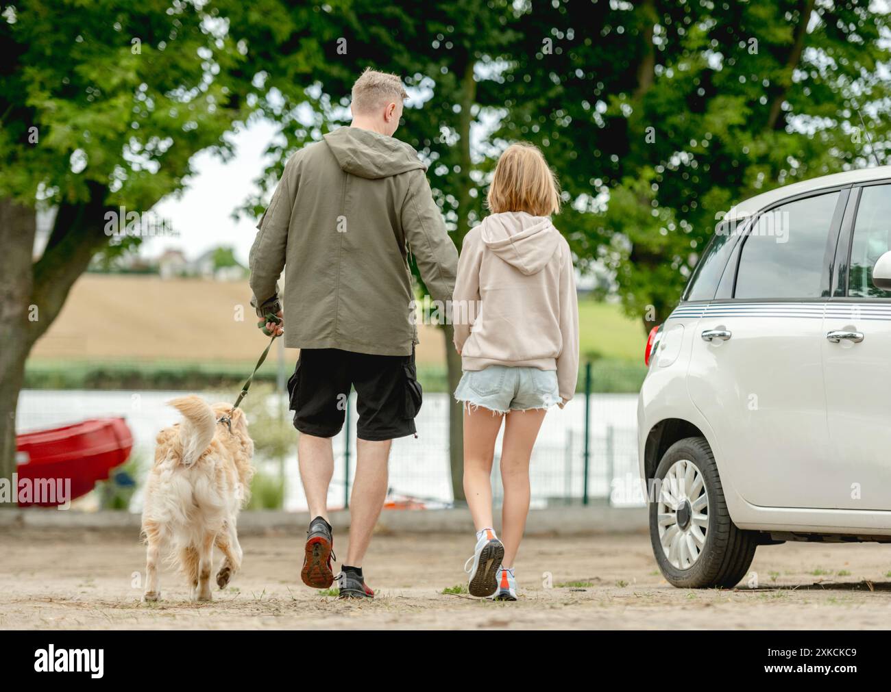 Dad With Daughter And Golden Retriever Dog Near Car On A Walk, View From Behind Stock Photo - Alamy