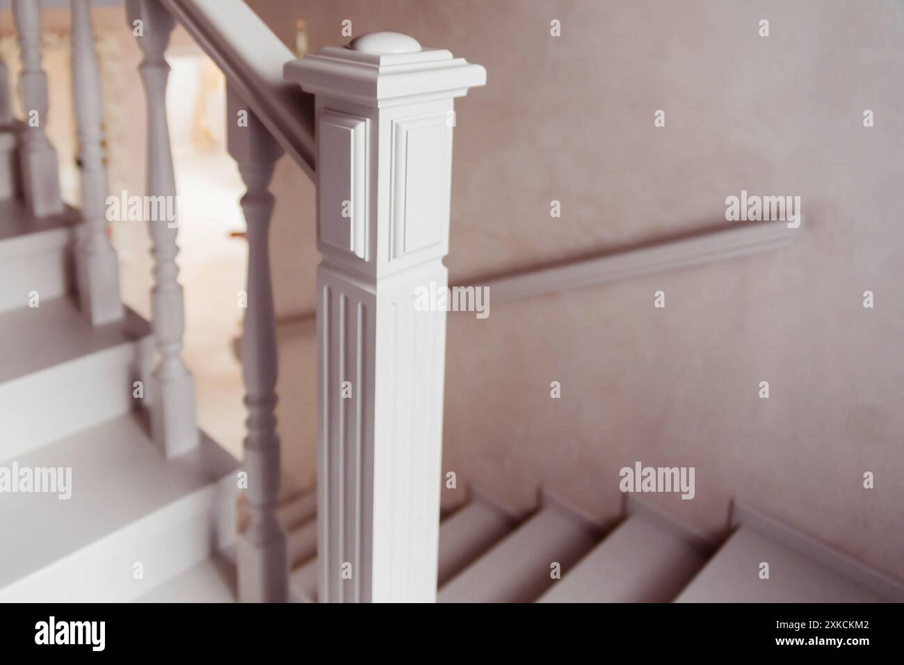 A close-up of a classic white staircase railing with intricate details ...