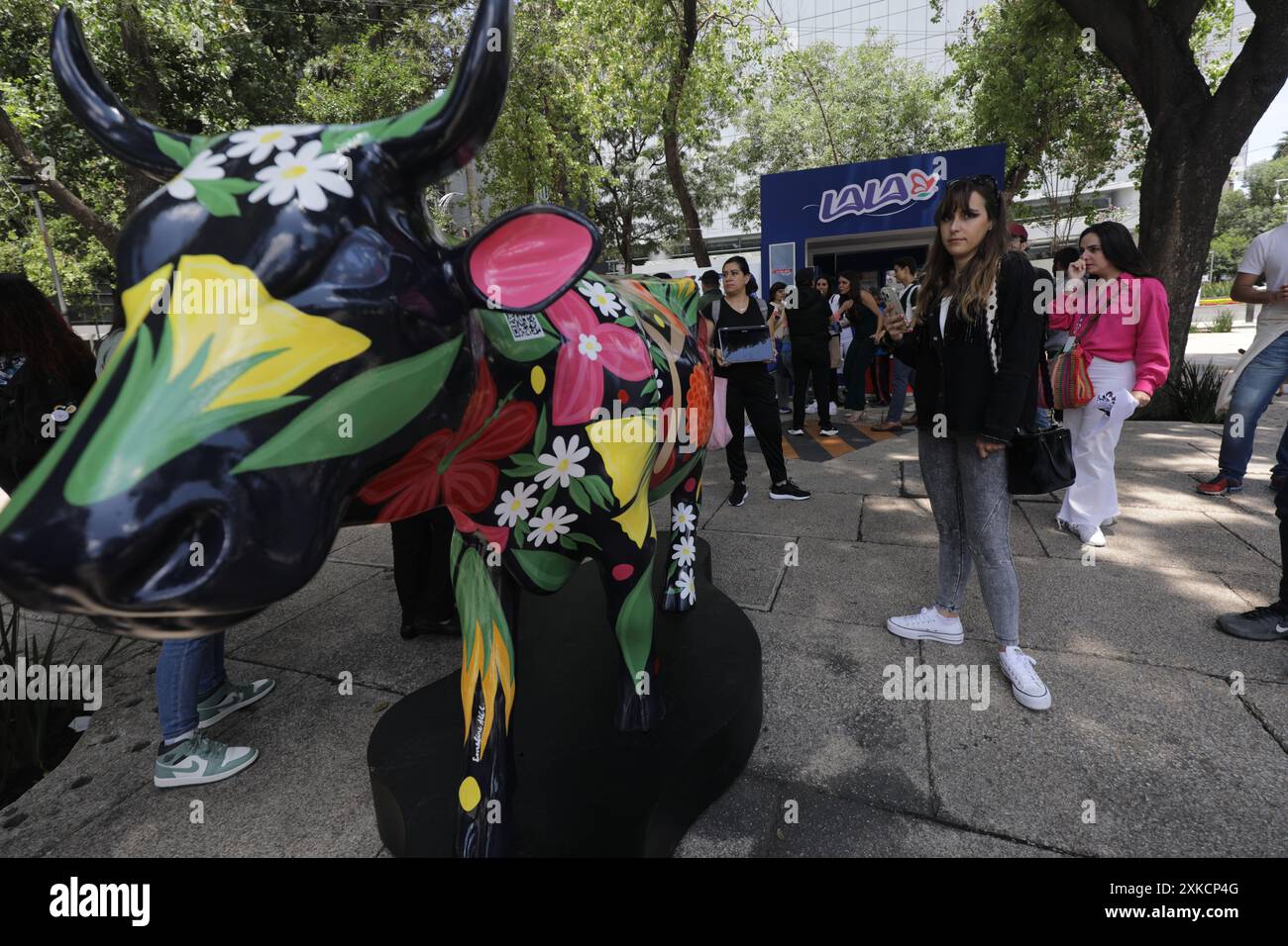 A woman takes a photo of a fiberglass cow painting by an artist during ...