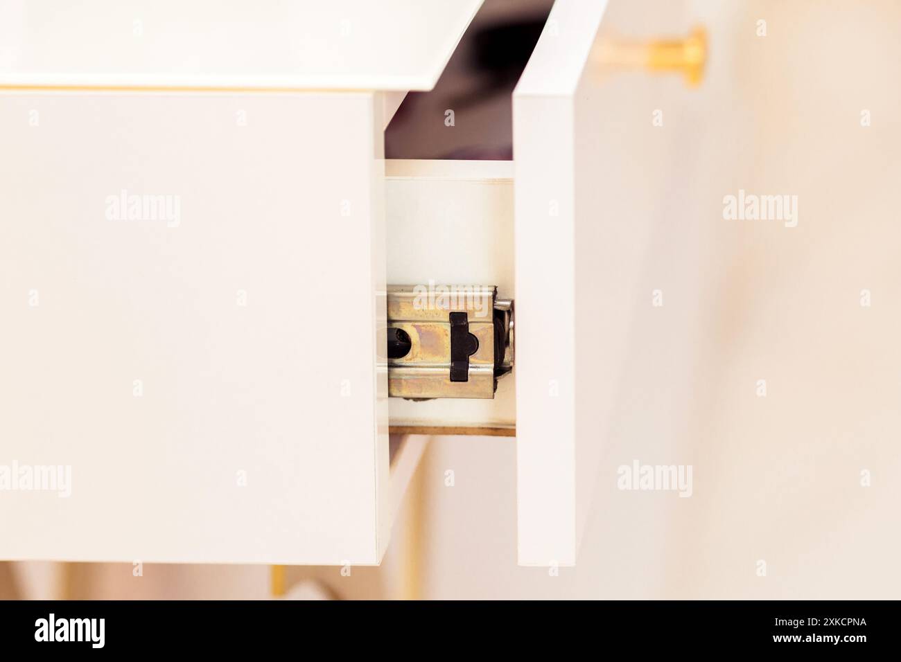 A close-up of a partially open drawer revealing its metal sliding ...