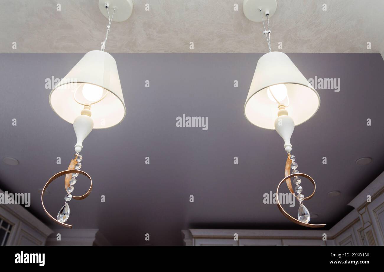 Two elegant pendant lights with white shades and crystal accents ...