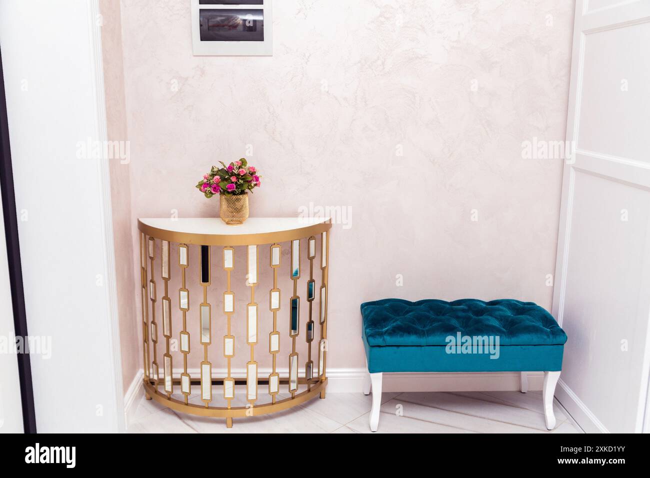 A stylish corner featuring a semi-circular console table with a vase of ...