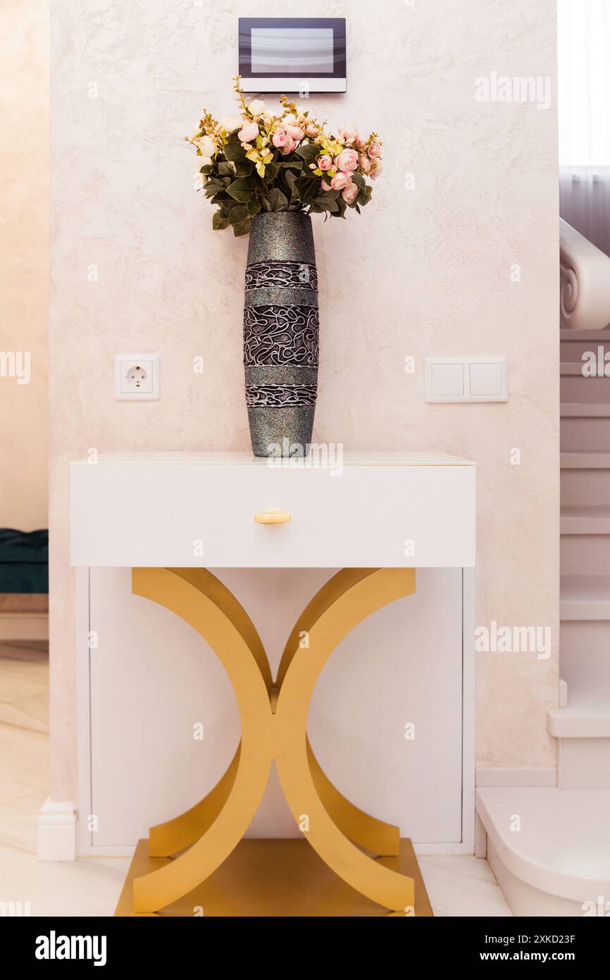 Elegant artificial flower arrangement in a decorative vase, placed on a ...