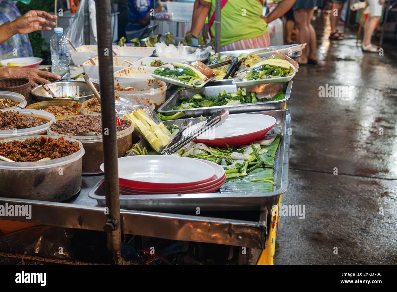 Asian street food vendor stall with various prepared dishes and ...