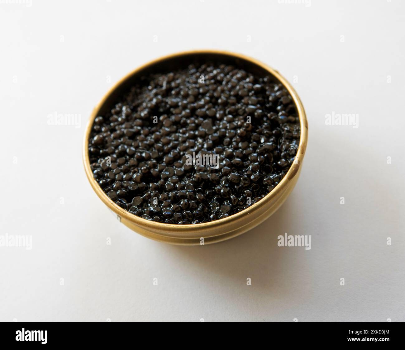 Black caviar in an open tin can on white background. Top view and ...