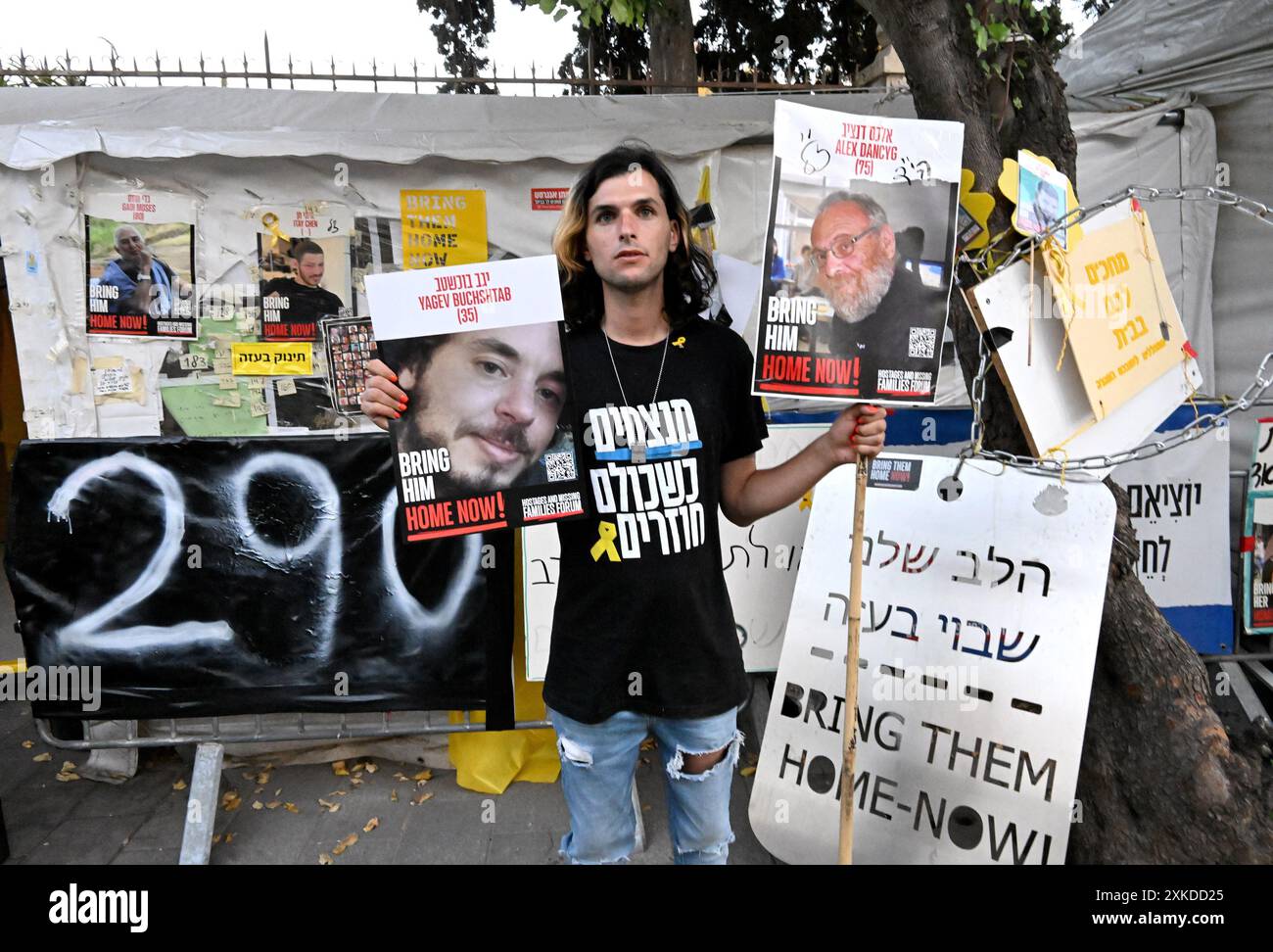 An Israeli holds posters of hostages Alex Dancyg, 76, and Yagev ...