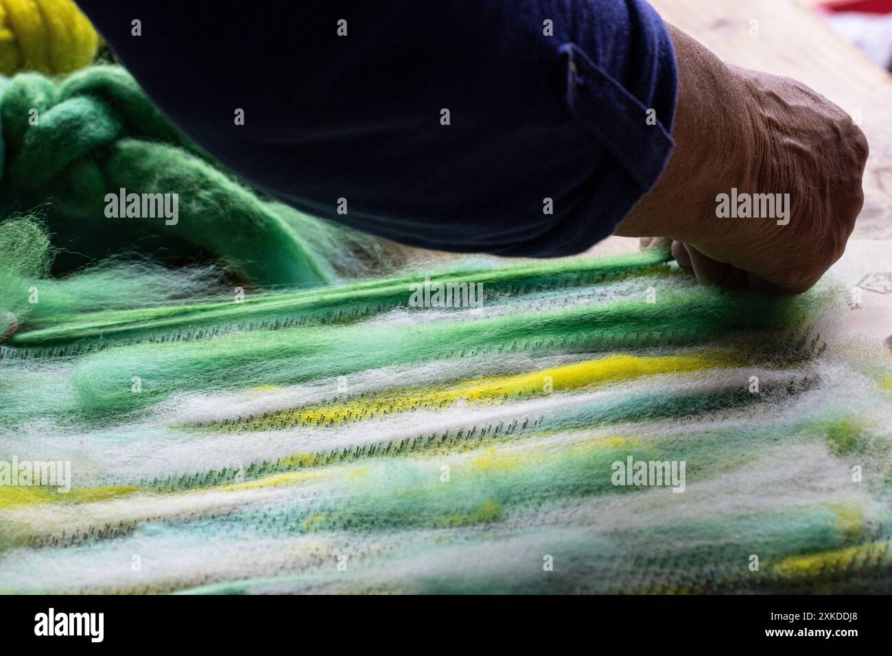 Coloured, dyed raw wool is applied side by side on a blending board ...