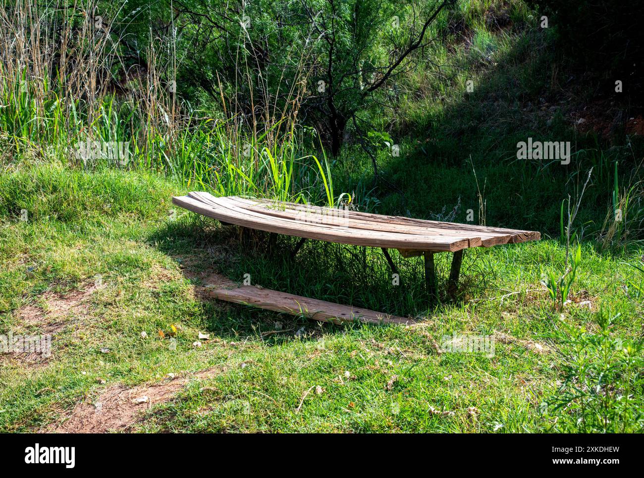 Over time a picnic table located next to a stream becomes buried with ...