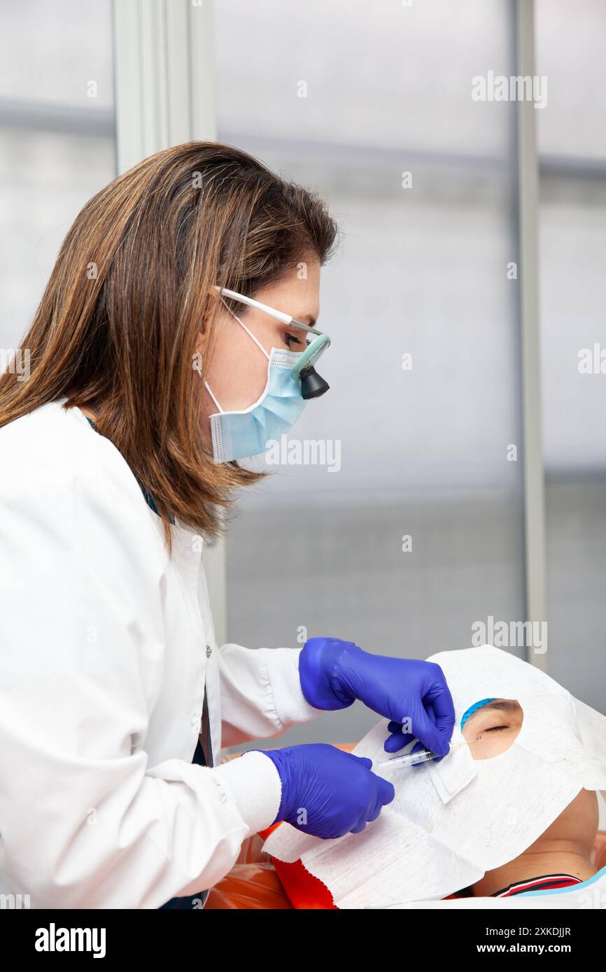 Skin lesion removal procedure. Dermatologist carrying out a removal of ...