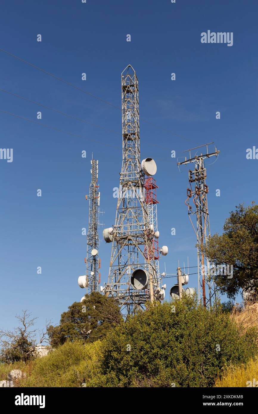 A tall communications tower with many antennas on top. The tower is surrounded by other towers ...