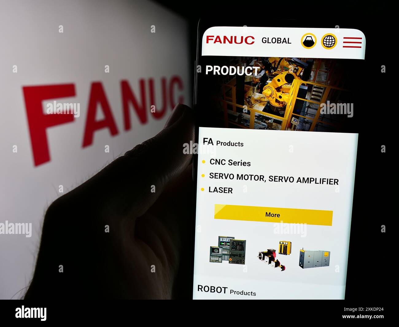 Person holding cellphone with webpage of Japanese robotics company ...