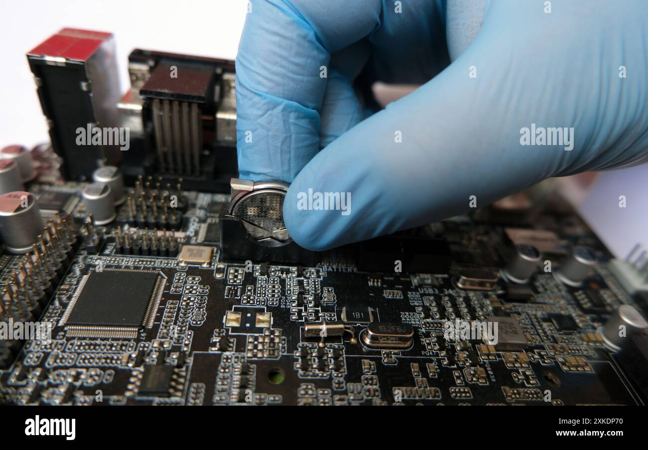Computer technician replaces the flat battery on a battery-backed ...