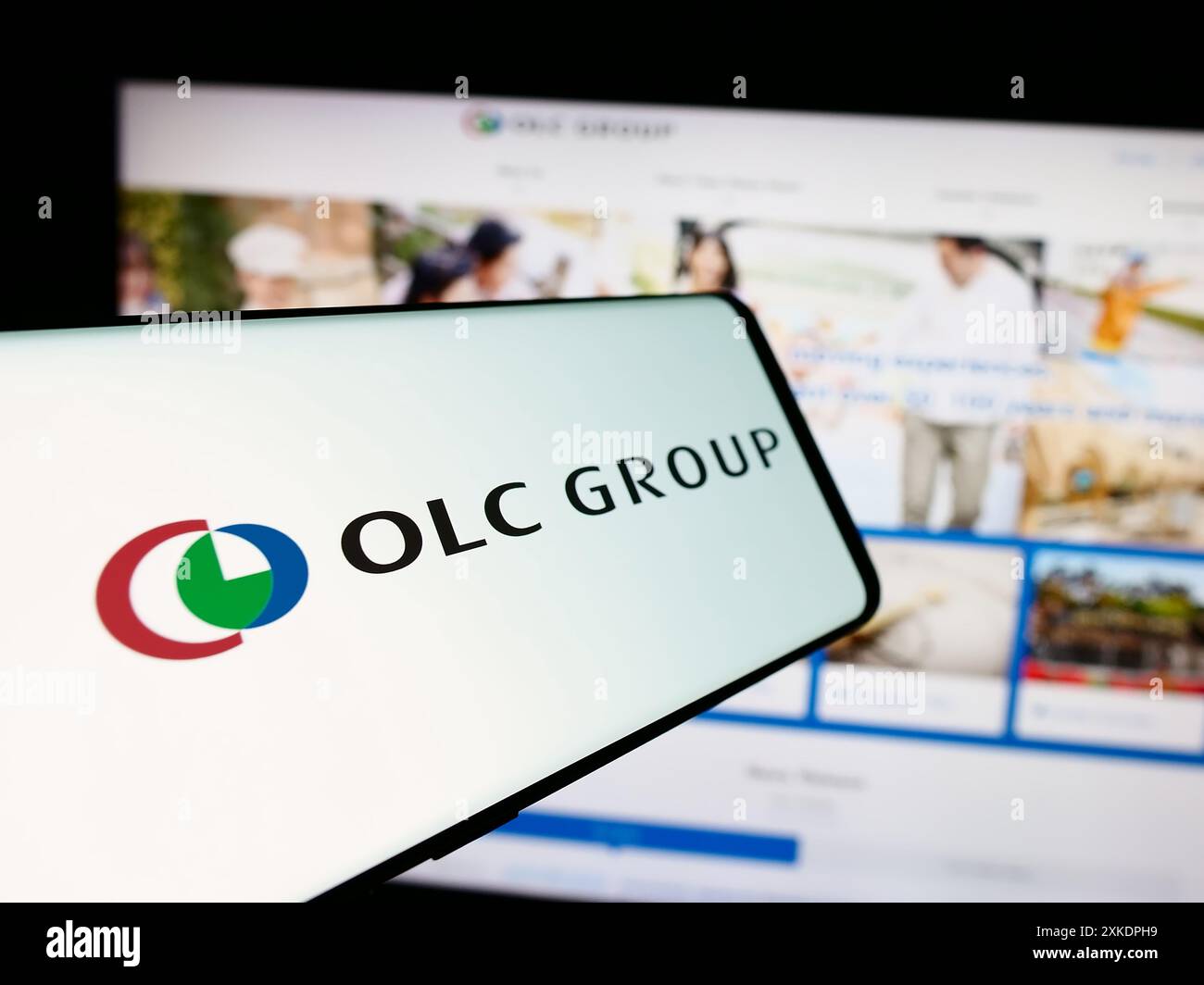 Smartphone with logo of Japanese tourism company Oriental Land Co. Ltd. (OLC) in front of ...