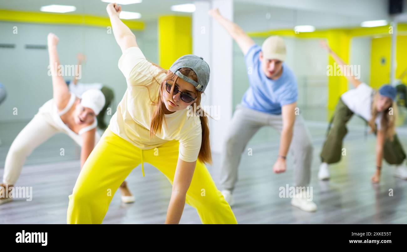 Excited positive teenage dancers having fun and learning modern dance ...