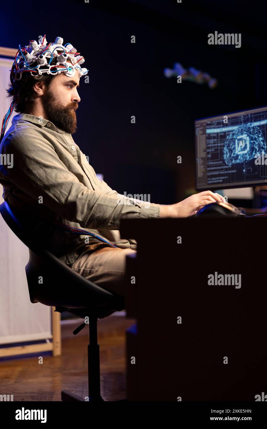 Programmer using EEG headset translating thoughts into PC commands using brainwave signals. Man ...