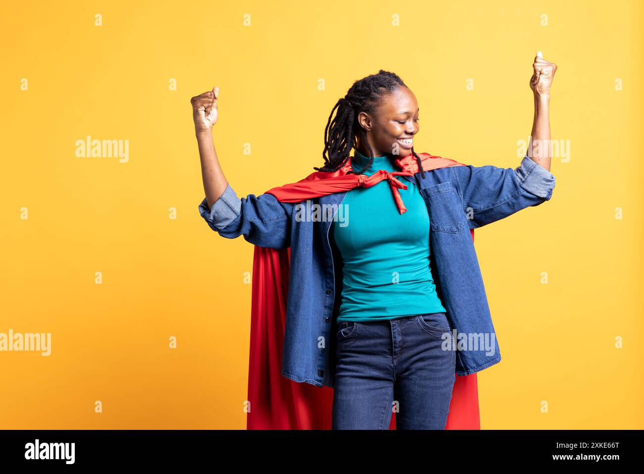 African american girl flexing muscles, wearing superhero costume for ...