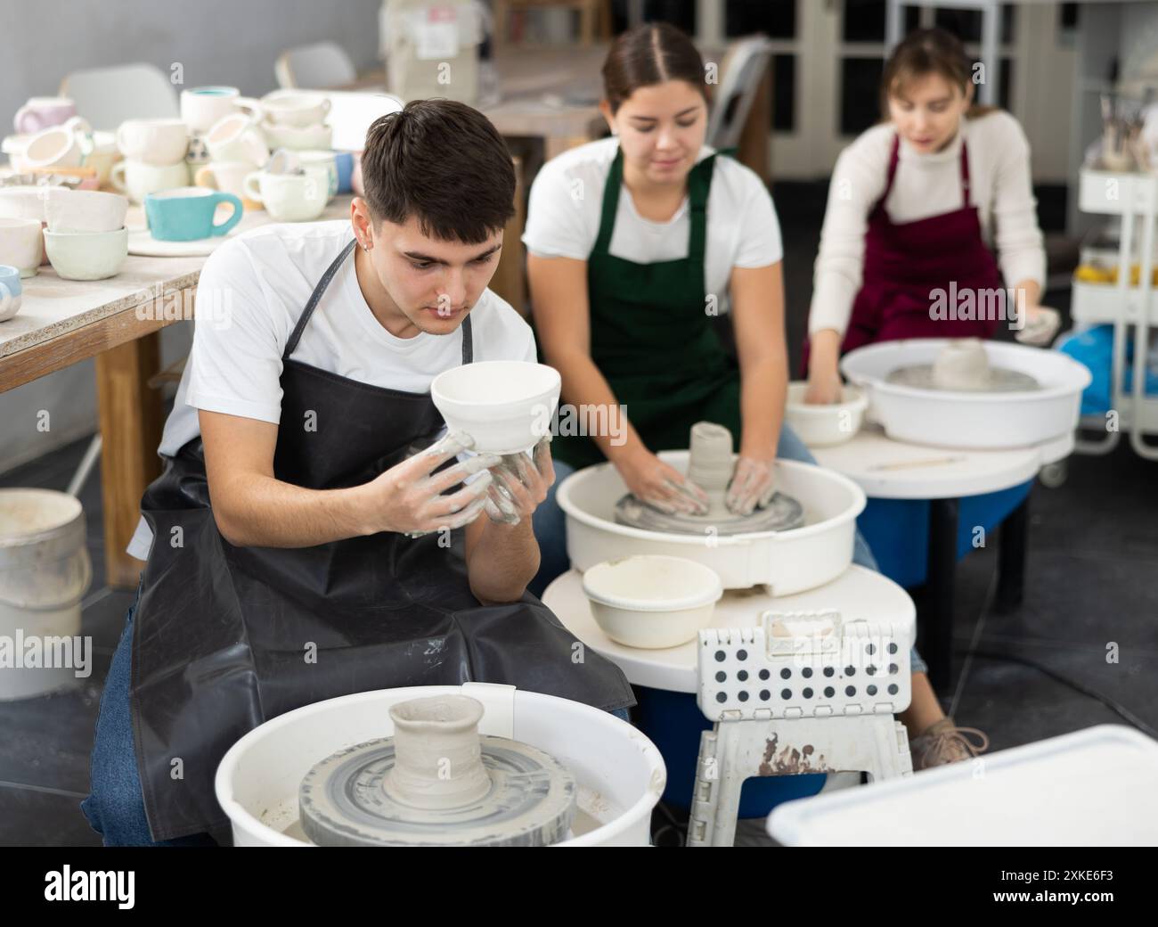 Young man holding clay bawl at pottery wheel Stock Photo - Alamy