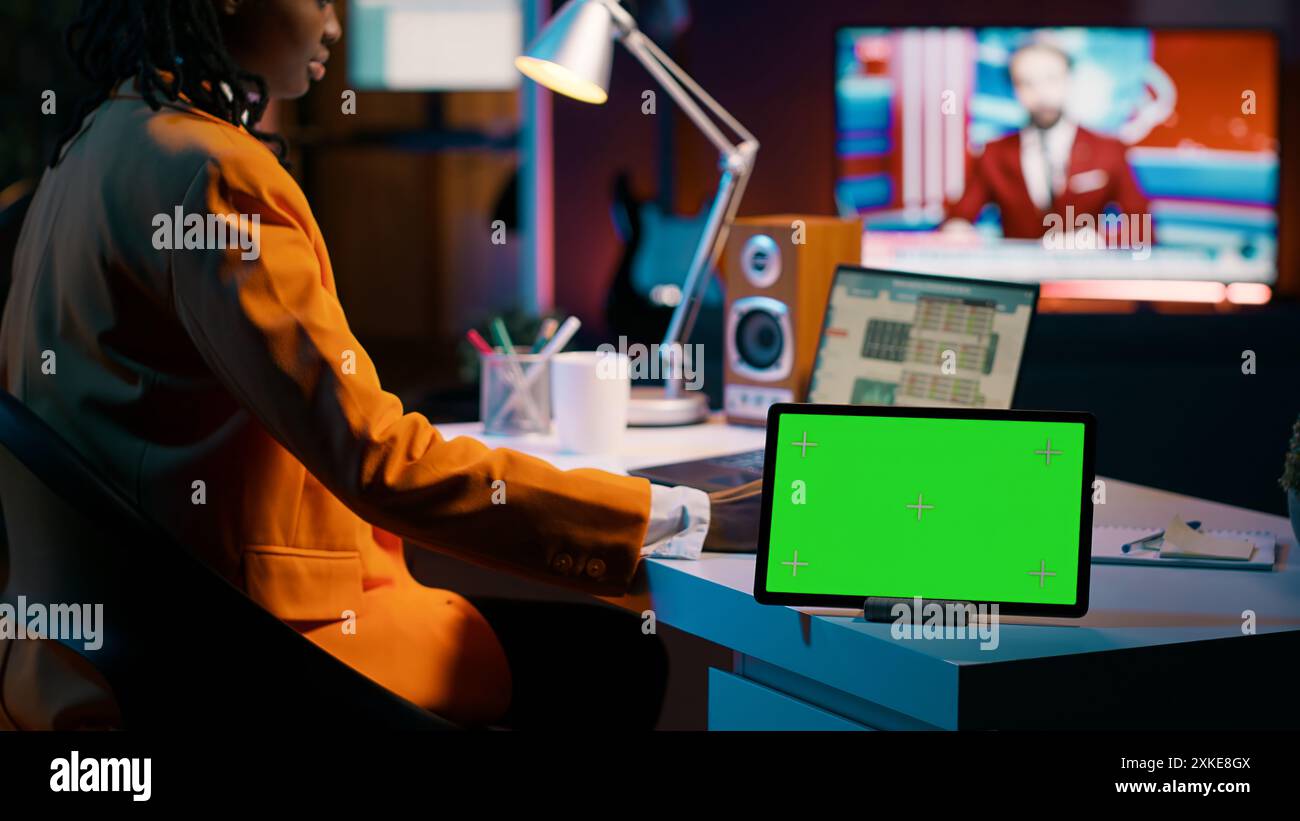 African american pupil looks at greenscreen display on tablet, learning ...