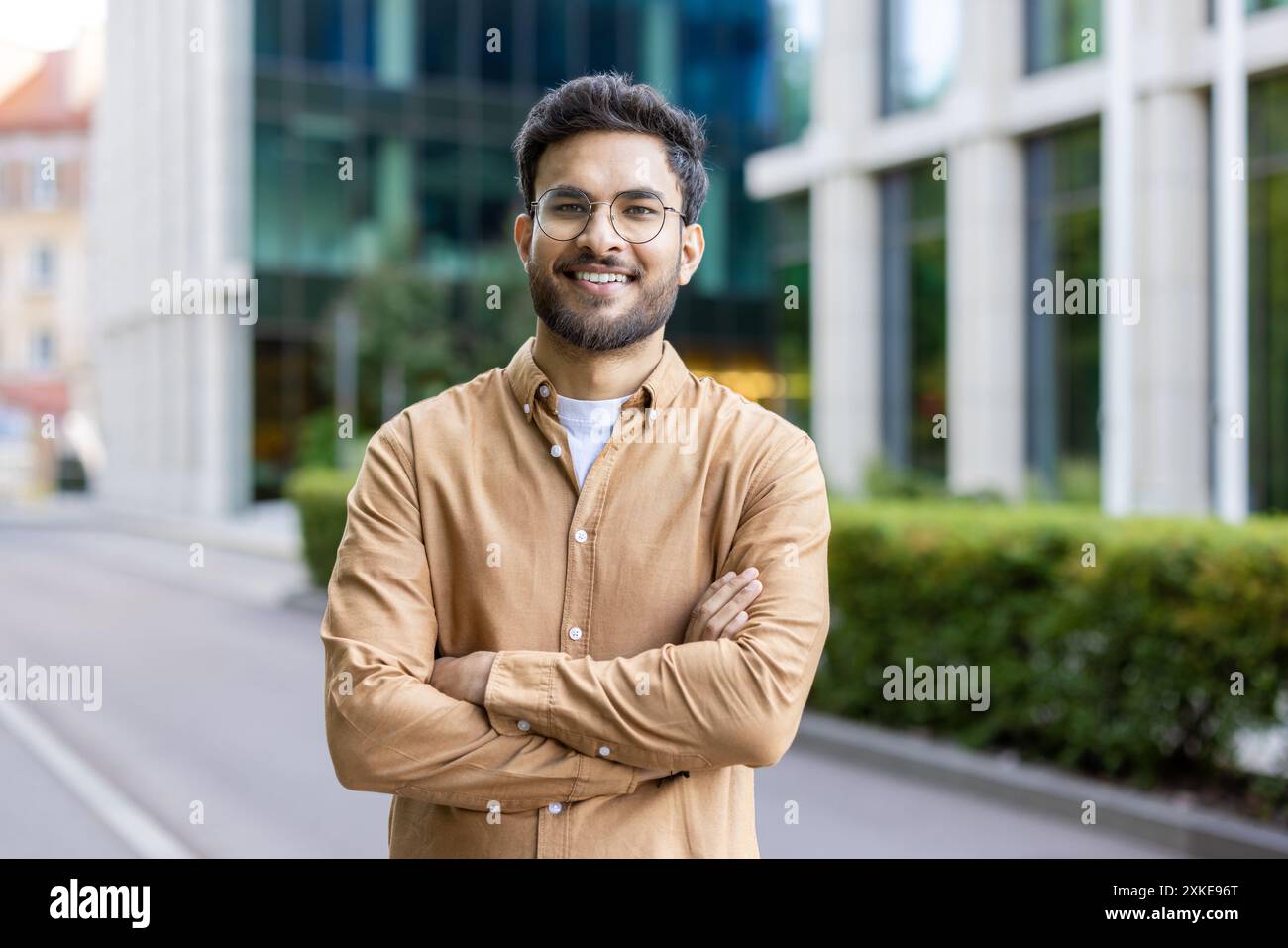 Young man with glasses standing confidently outside modern office ...