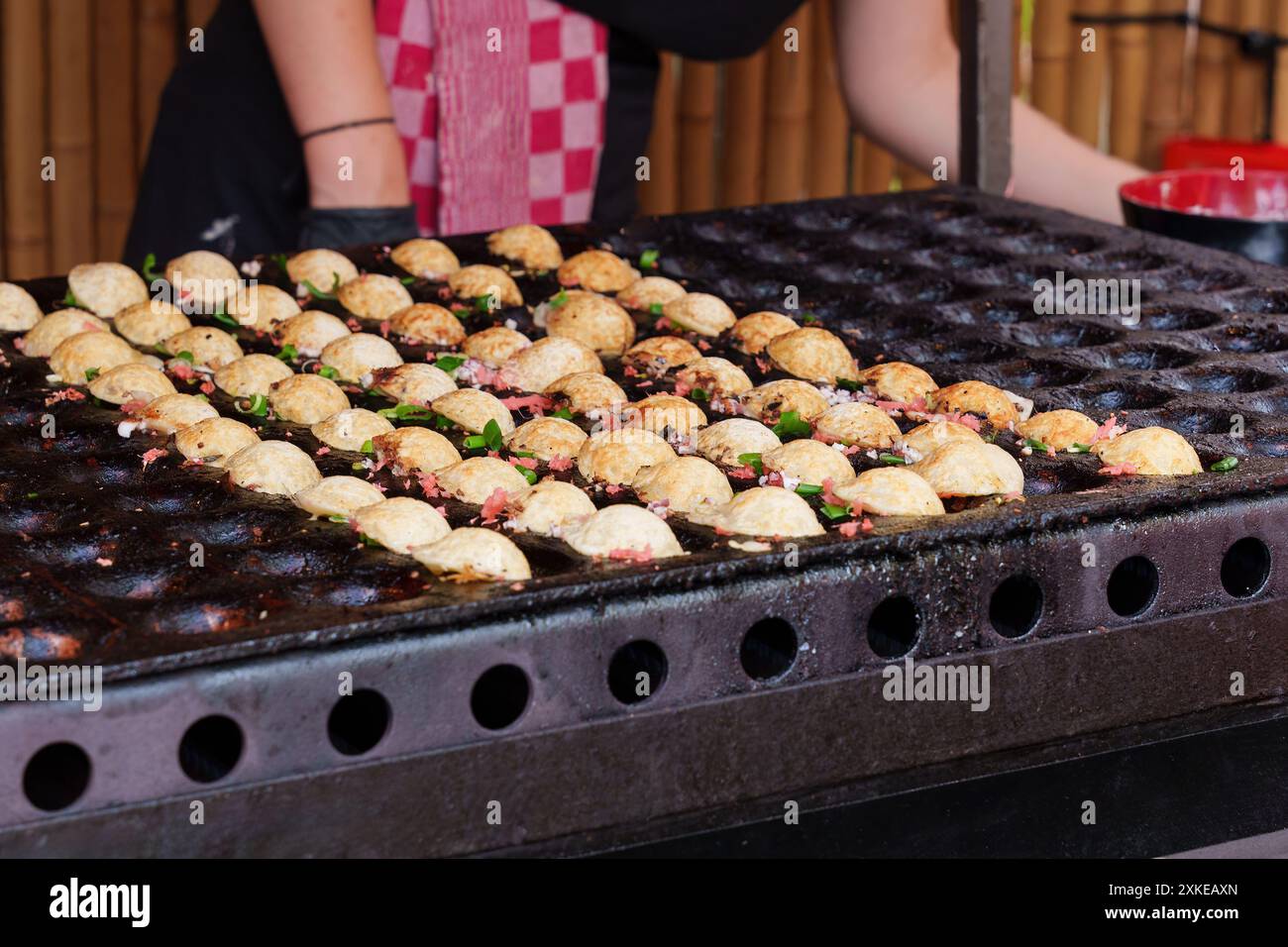 Chef wearing black gloves cooking takoyaki, Japanese appetizer ball ...