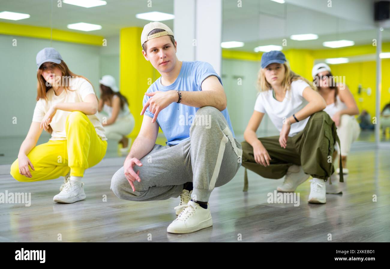 Teenage boy sitting in breakdance pose in dance hall Stock Photo - Alamy