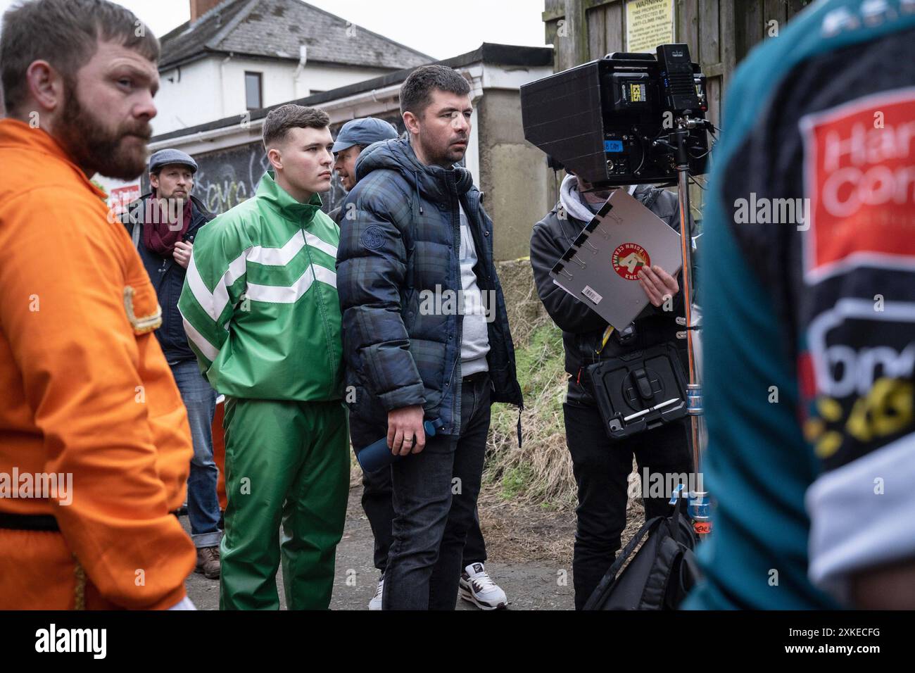 KNEECAP, center, from left: Mo Chara, director Rich Peppiatt, on set ...