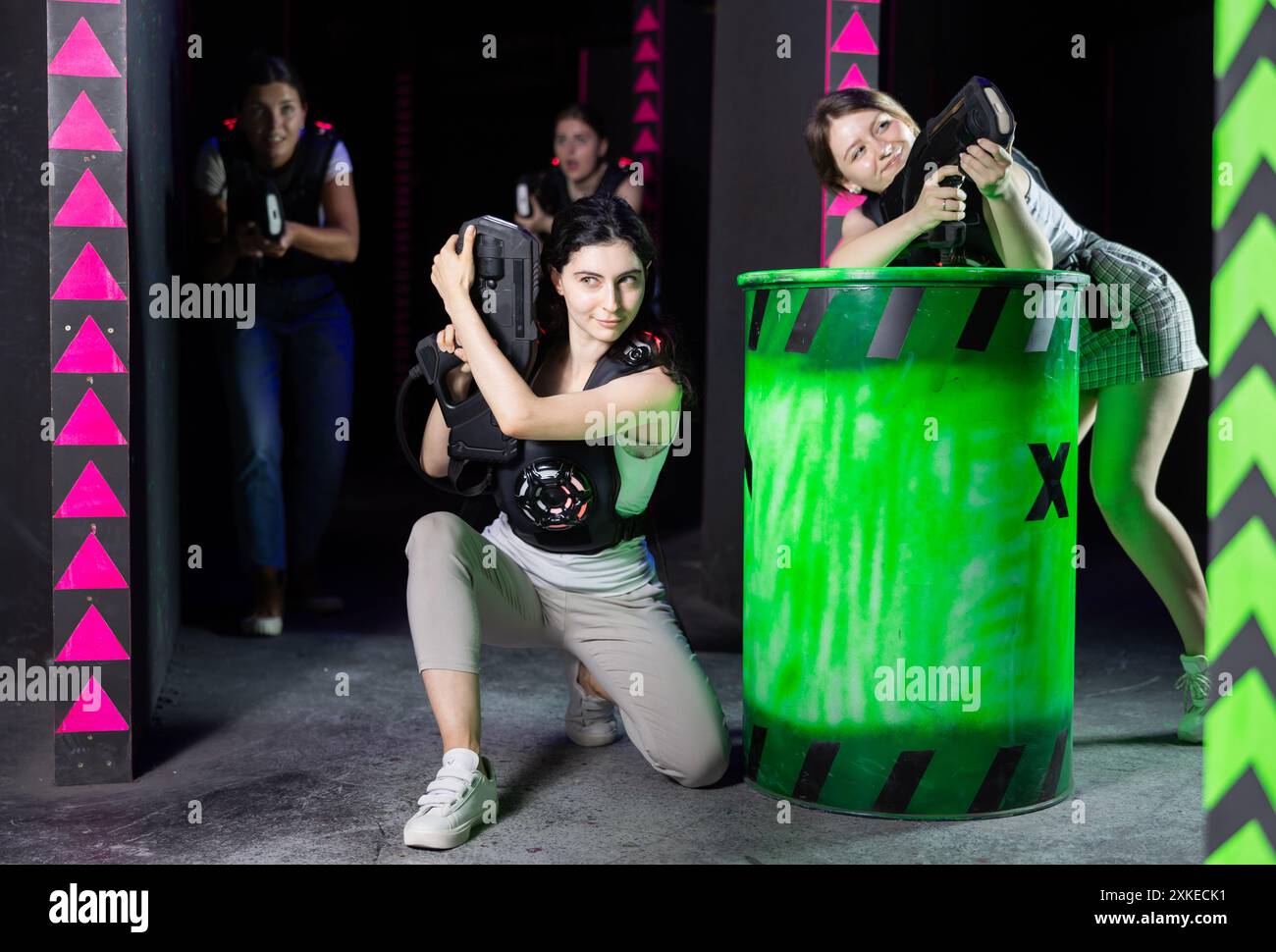 Laser tag players cheerful positive smiling girls playing in teams in ...