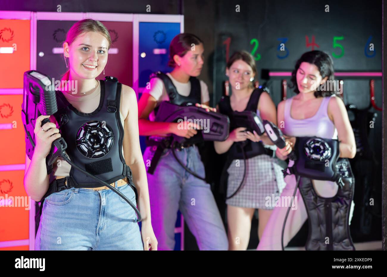 Cheerful and happy girl pose in locker room before laser tag match ...