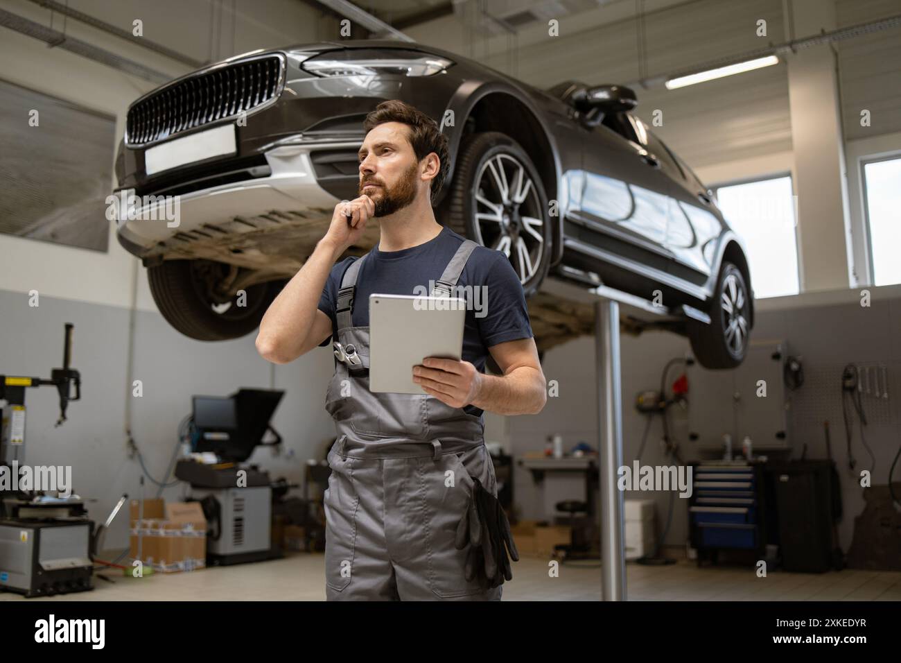 Mechanic inspecting car repair work using tablet in the garage Stock ...