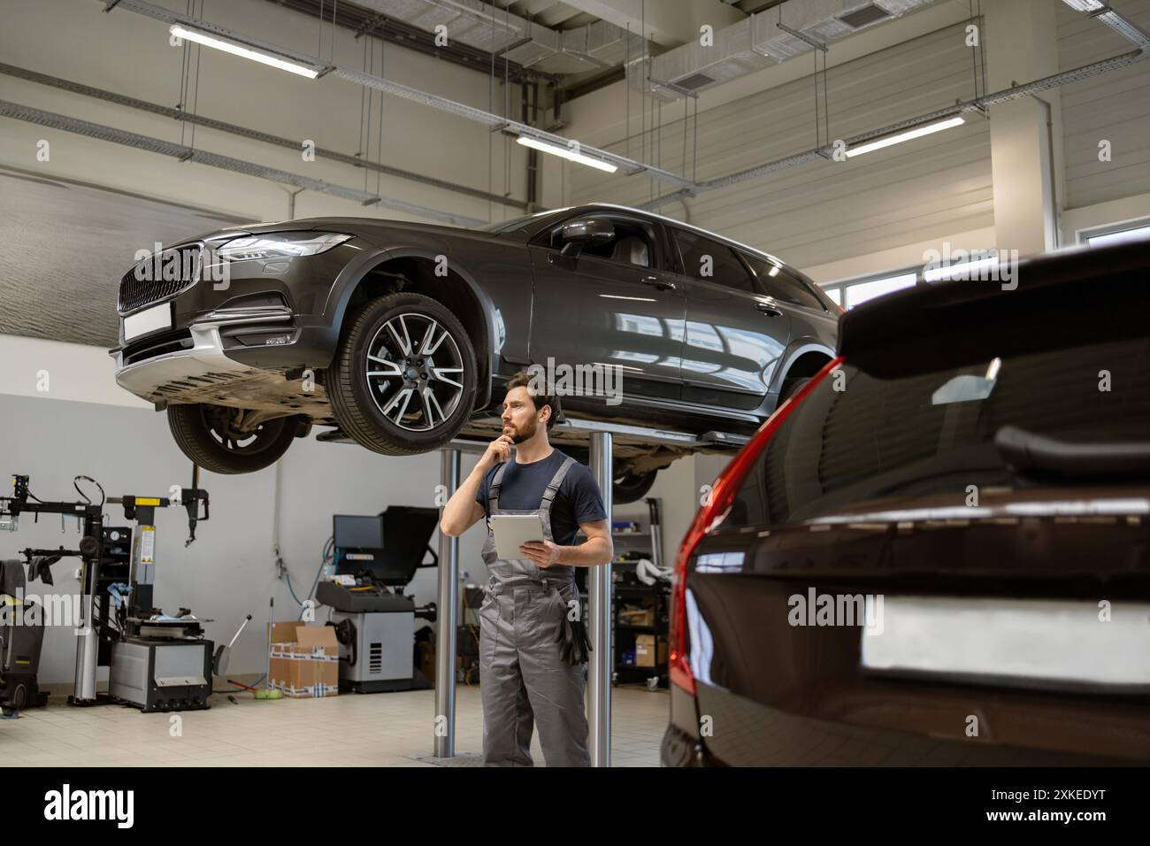 Mechanic inspecting car in automotive repair garage Stock Photo - Alamy