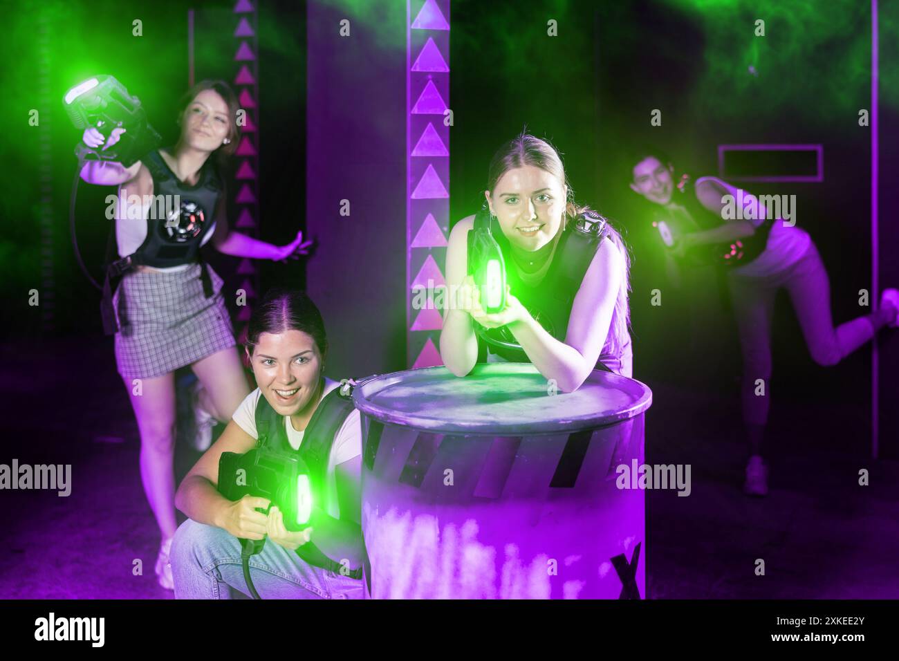 Laser tag players cheerful positive smiling girls playing in teams in ...
