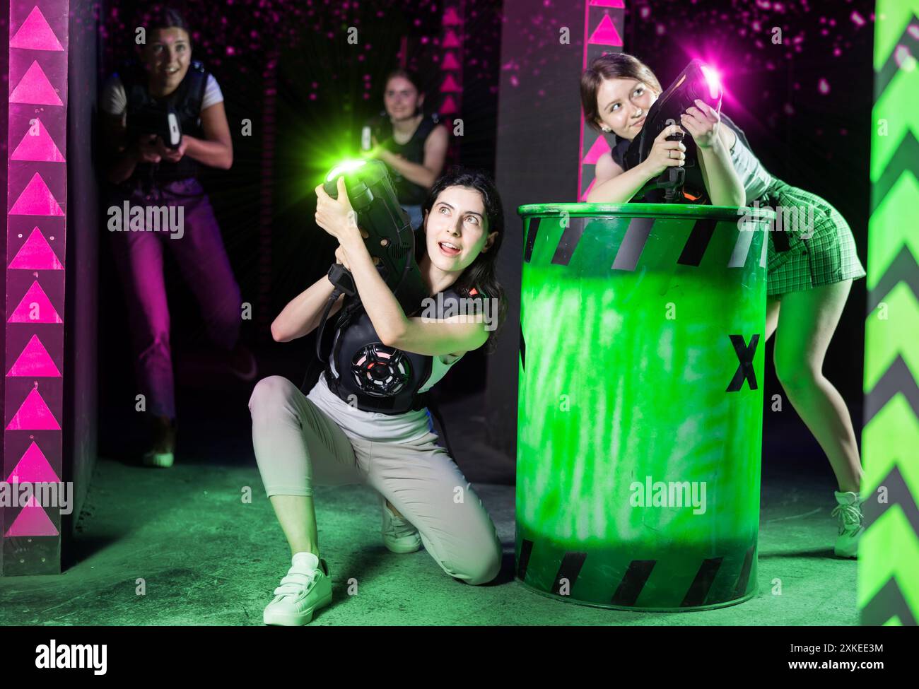Laser tag players cheerful positive smiling girls playing in teams in ...