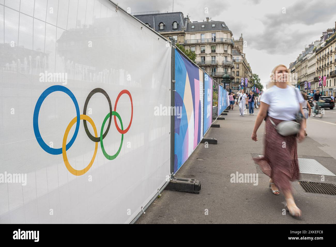 240722 A woman pass by the Olympic Rings signage during day -4 of the ...