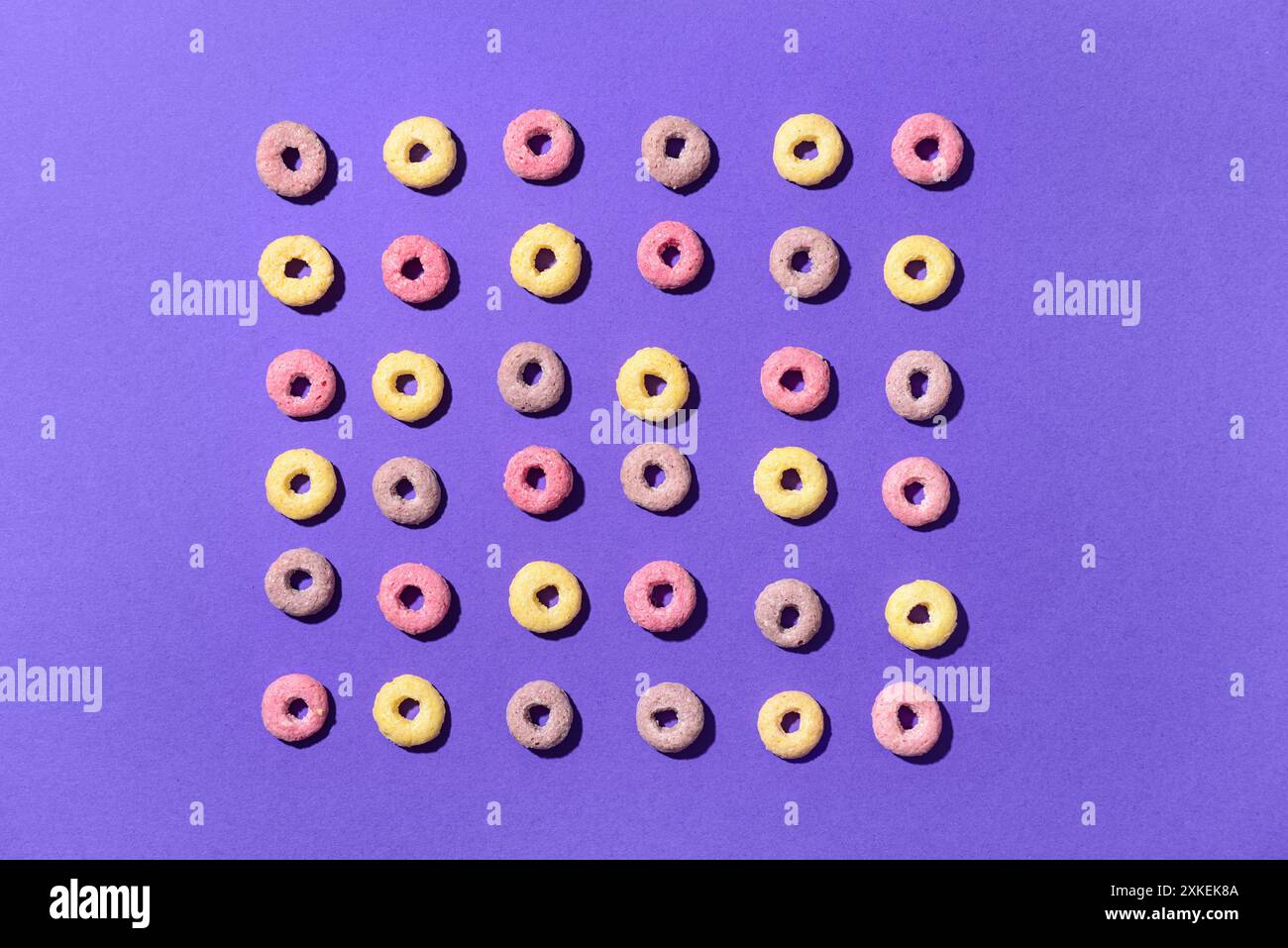 Colorful sweet cereal rings on purple background Stock Photo - Alamy