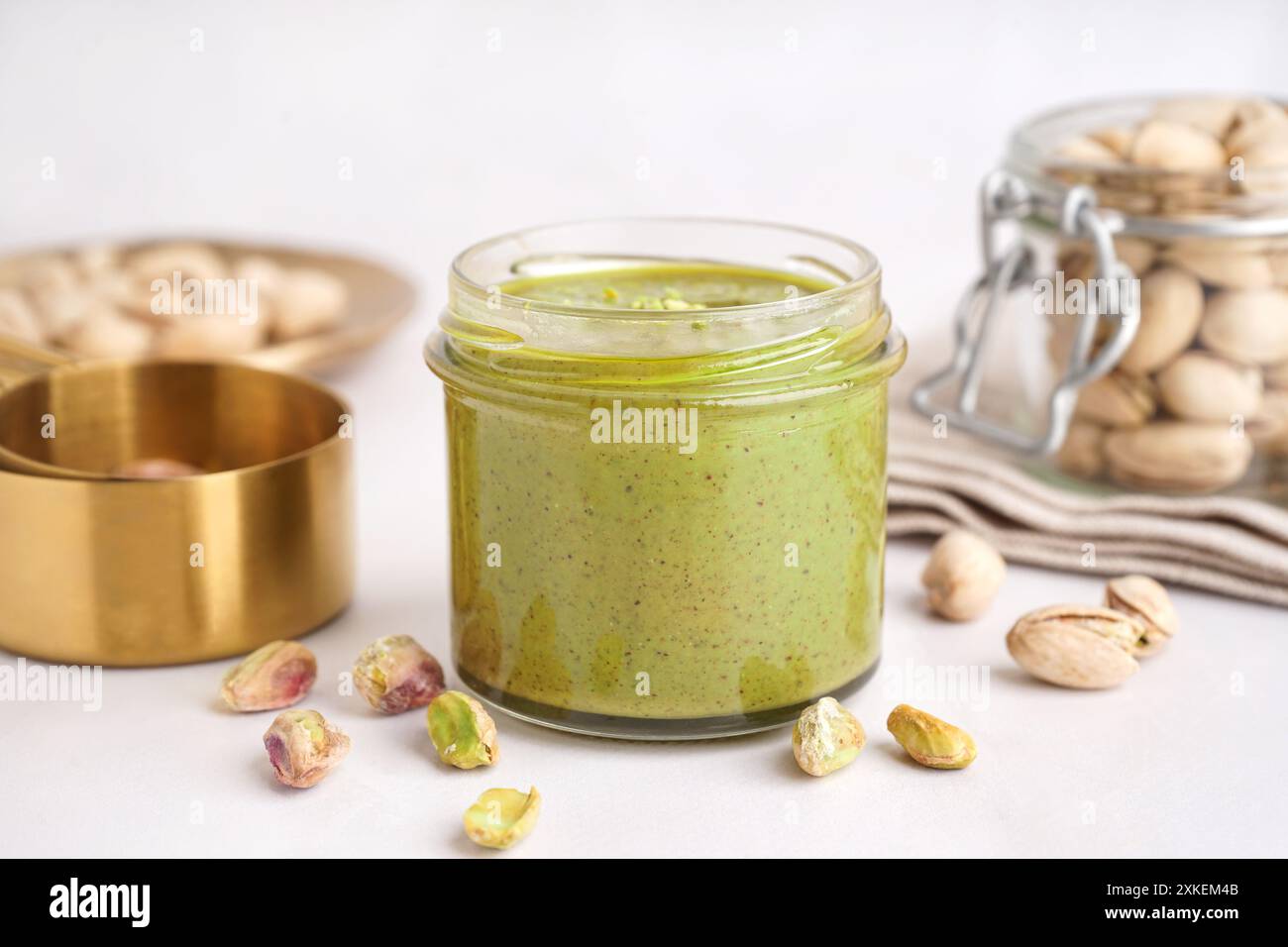 Jar of pistachio paste and measuring cups on white background Stock ...