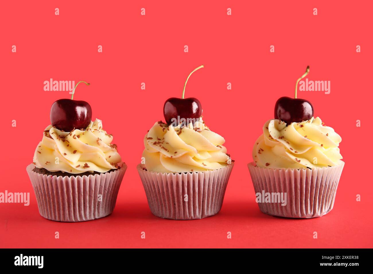Sweet cherry cupcakes on red background Stock Photo - Alamy