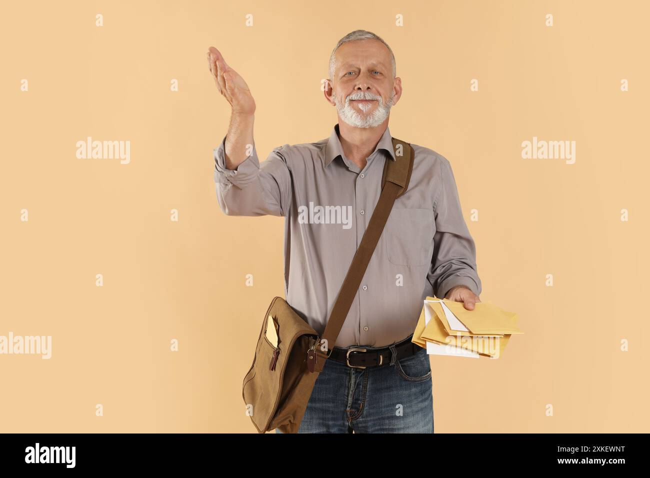 Happy postman with brown bag delivering letters on beige background ...