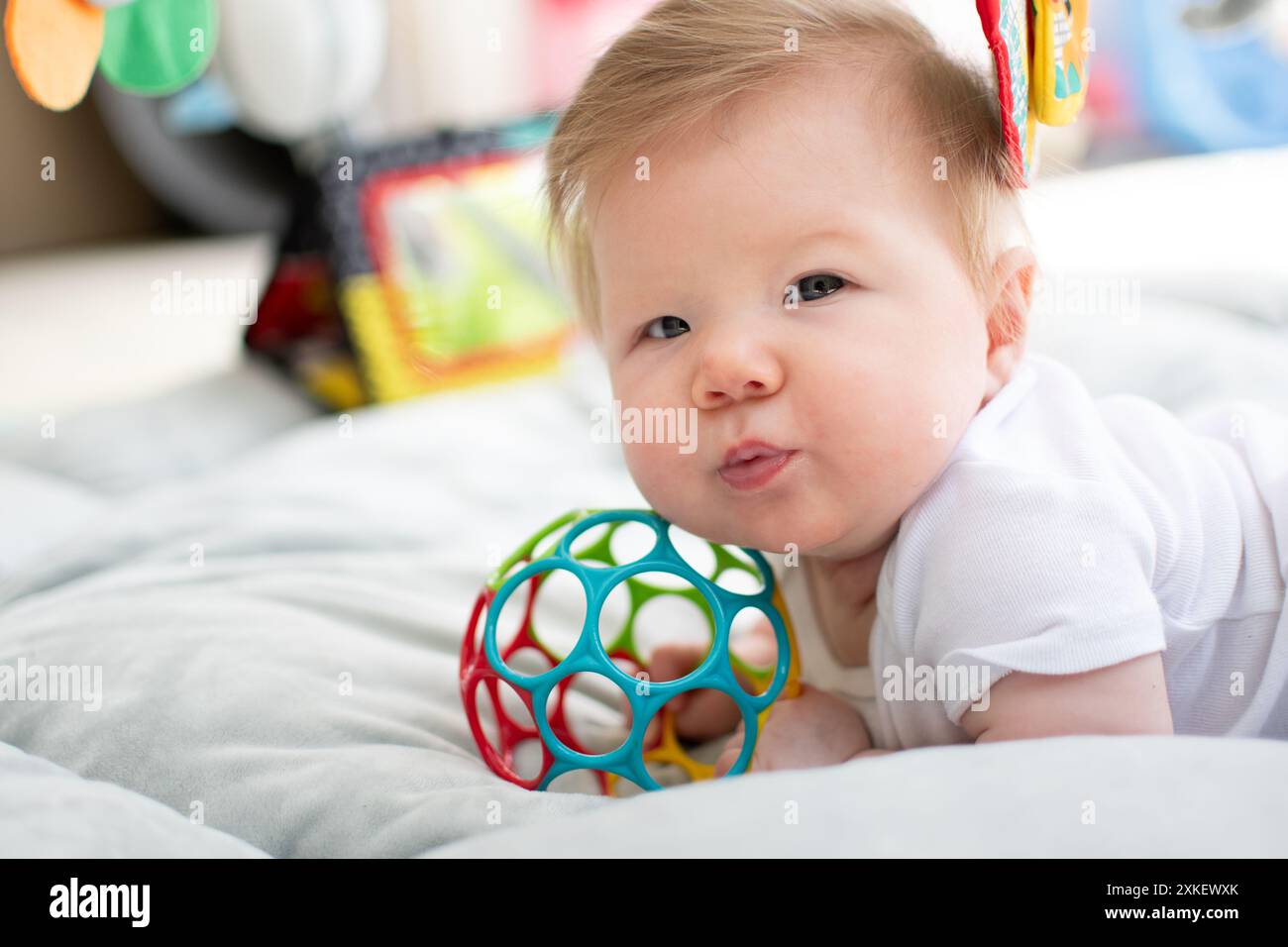 Cute Caucasian baby girl during tummy time. 3-month-old baby playing ...