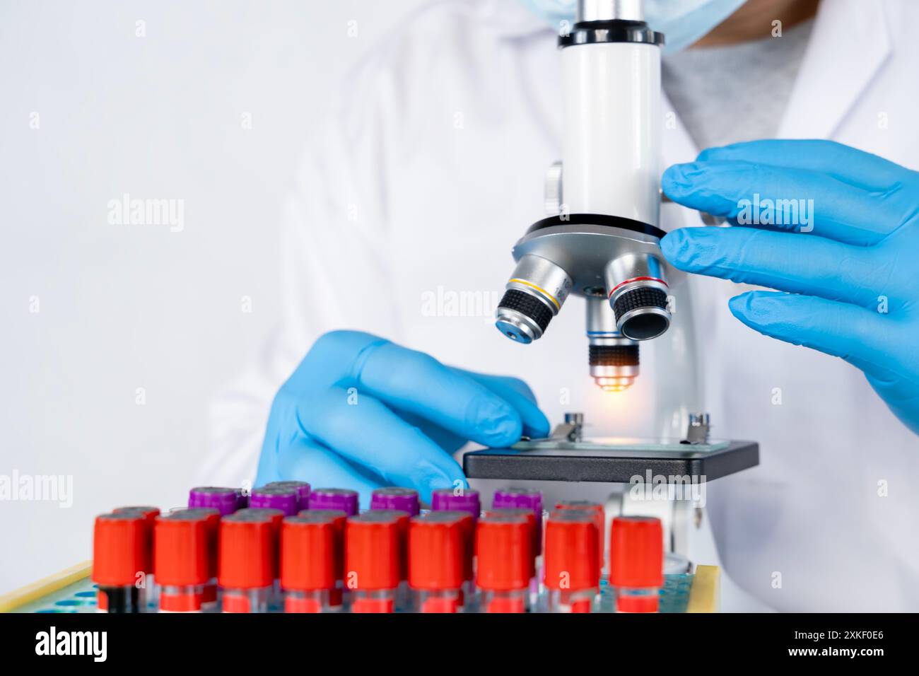 Doctor hand taking a blood sample tube from a rack with machines of ...