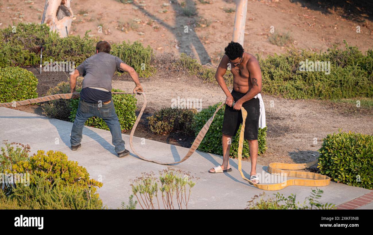 Home owners seen assisting Cal Fire Firefighters in setting up hose ...
