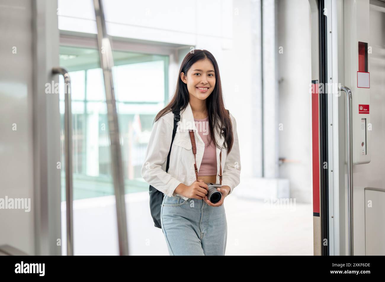 A beautiful, positive young Asian female traveler with a backpack and a ...