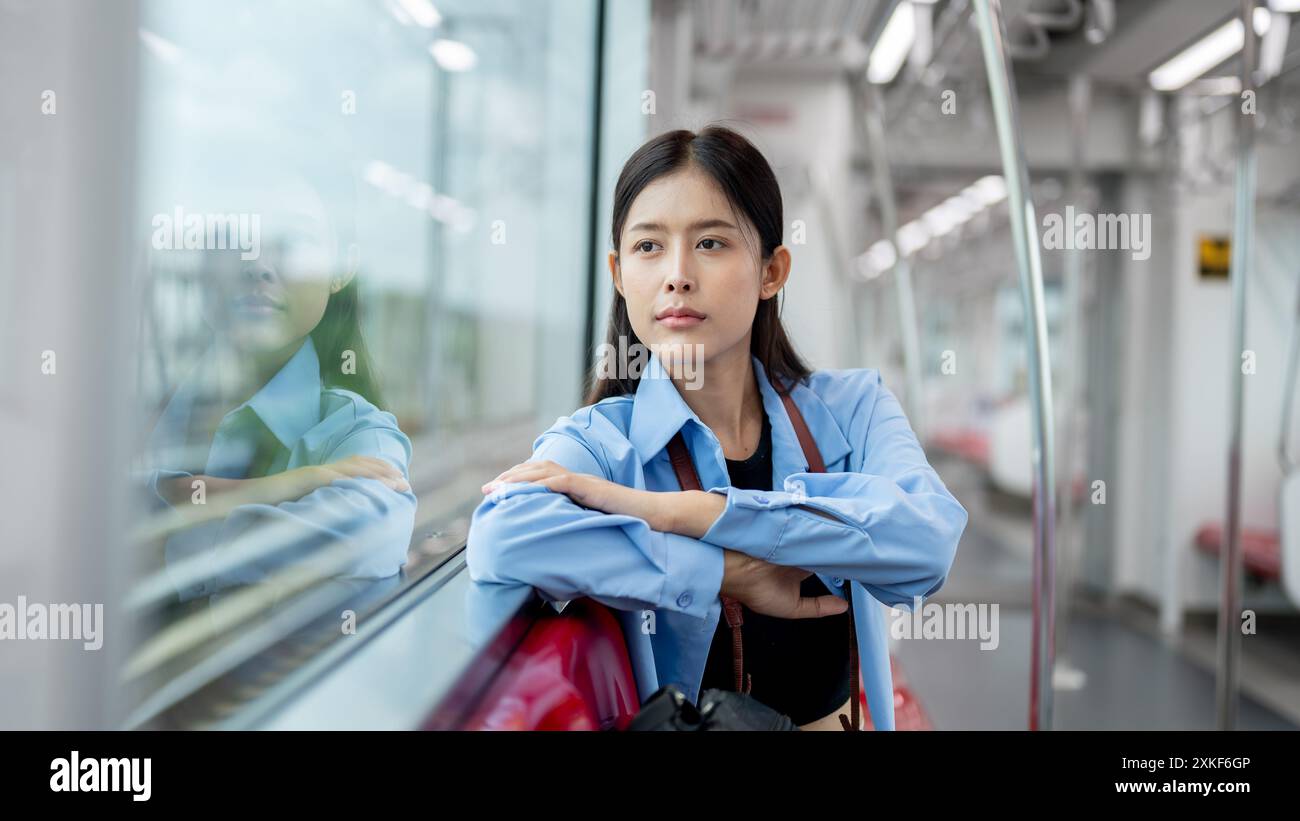 A positive, thoughtful young Asian female tourist passenger is thinking ...