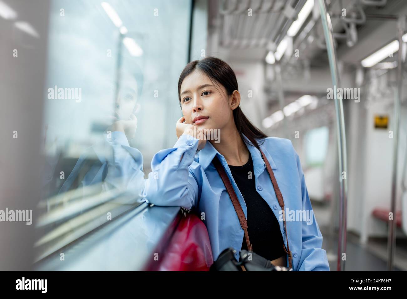 A positive, thoughtful young Asian female tourist passenger is thinking ...