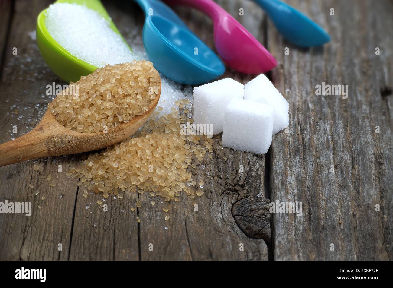 Set of colorful plastic measuring spoons with brown cane sugar and ...