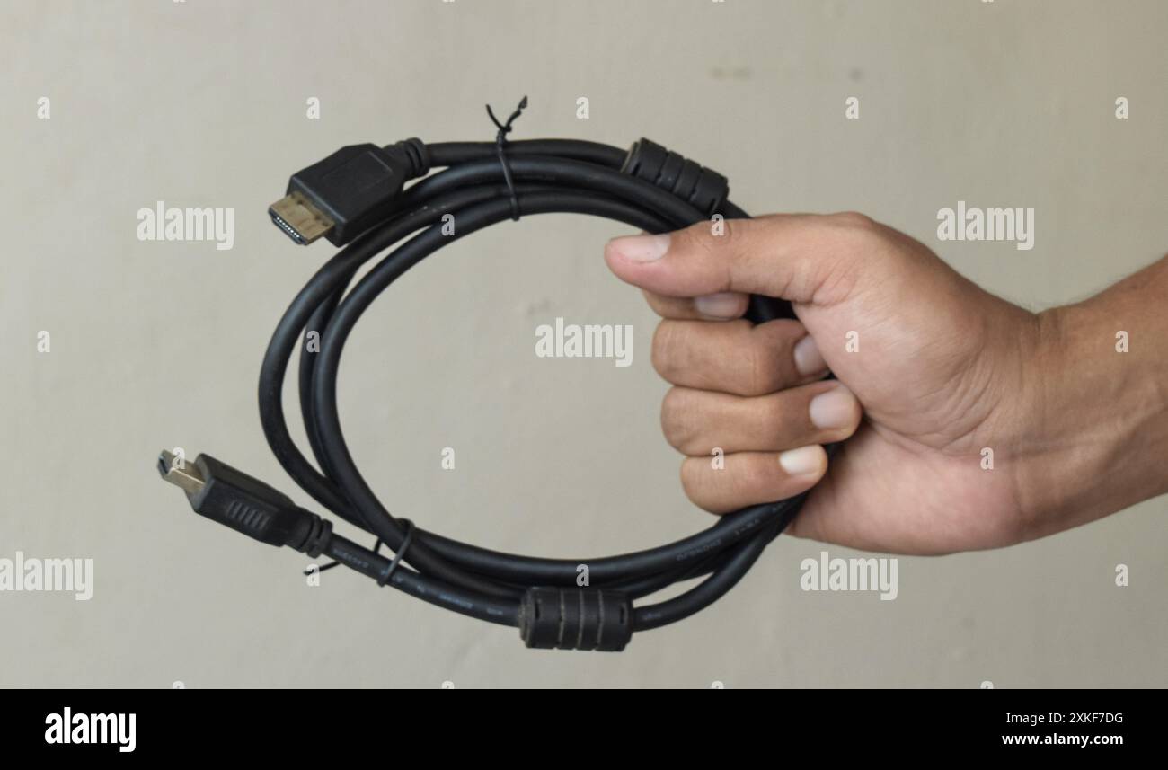 man hands holding black HDMI cable connector Stock Photo - Alamy